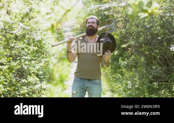 Portrait of bearded man farmer with shovel having fun in a farm ...