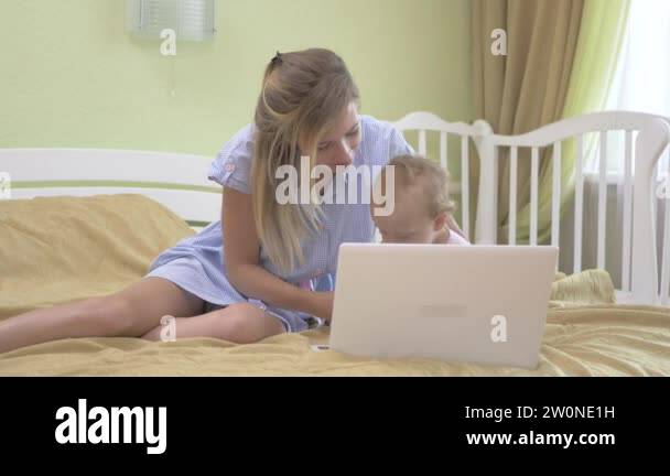 Baby typing on a laptop keyboard. Little girl opens and closes lid of ...