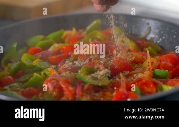 The cook flavors the vegetables in a pan and sprinkles with salt Stock ...