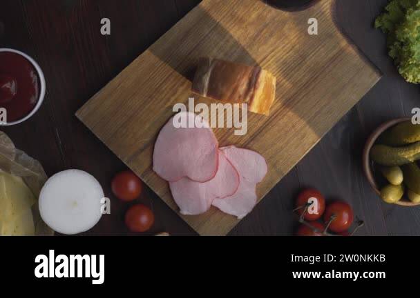 Flat lay video of tasty natural ham is sliced by sharp knife on the ...