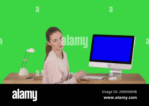 Charming woman presenting something on the screen of computer talking ...