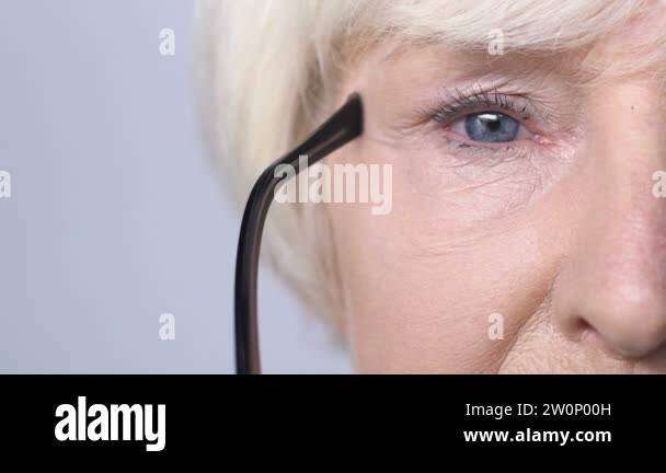 Mature lady putting on glasses for better vision, age-related problems ...