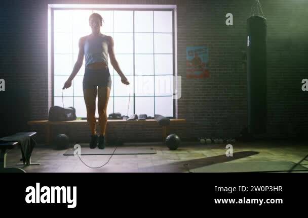 Strong Athletic Woman Exercises with Jumping Rope in a Loft Style ...