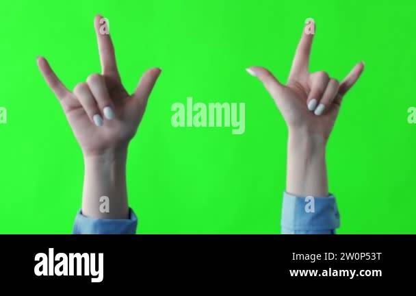 Sign of the horns with fingers on green screen. Simbol of heavy metal ...