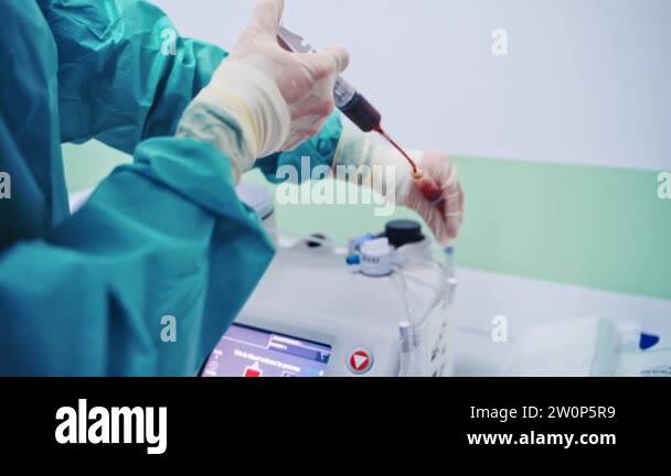 Stem cells injection procedure. Female worker pours blood from syringe ...