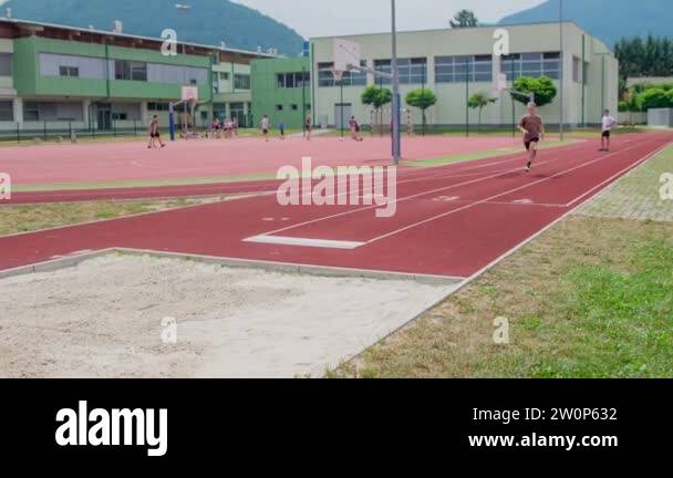 Elementary school student performs a long jump. He jumps really far and ...