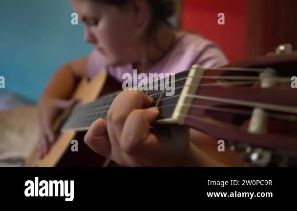 Children learn to play the guitar. Close-up of a guitar and strings ...