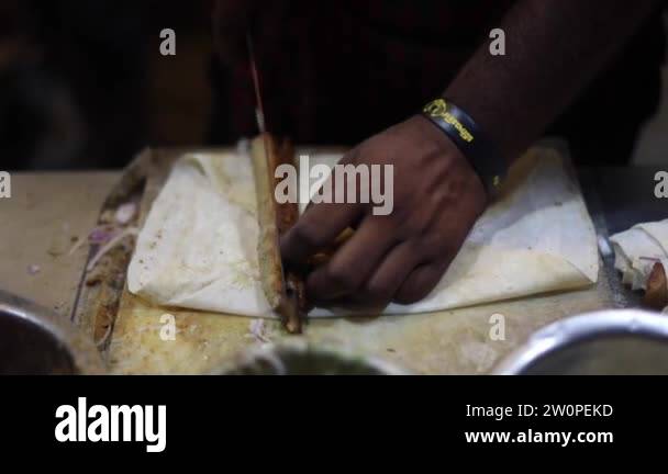 Man wrapping mutton seekh kabab in rumali roti, Indian bread. Mutton ...