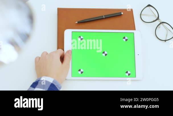 White tablet device with green screen in hands of Caucasian woman ...