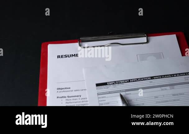Employment Application form on top of resume on office table. Slide ...