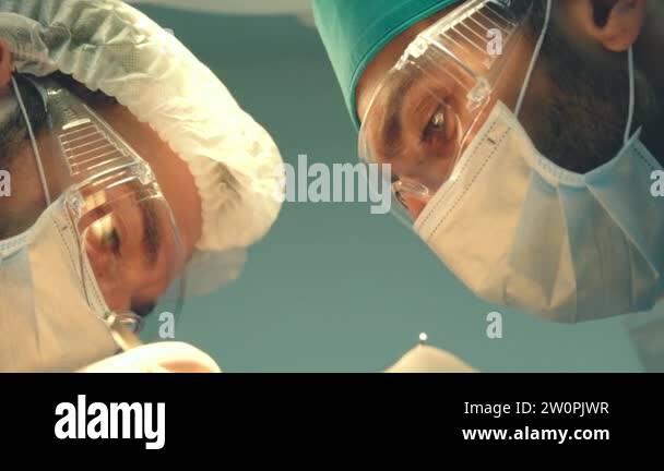 Baldness treatment. Hair transplant. Surgeons in the operating room ...