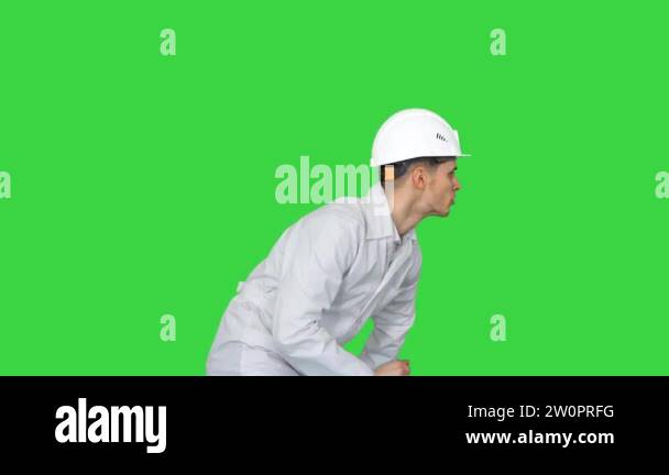 Young workman with helmet in white robe enjoy dancing on a Green Screen ...