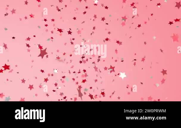 Red and white, shiny stars of confetti fly from left to right on a ...