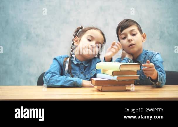 Two kids choosing between stack of books and laptop. Laptop is the ...