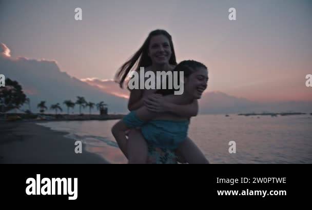 Hipster teenage girls having fun with piggyback ride on beach Stock ...