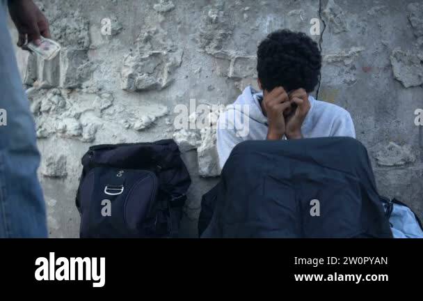 Crying homeless man sitting street, passerby donating money to poor ...