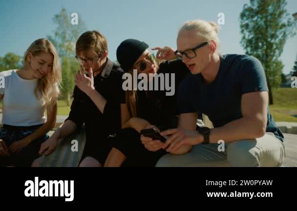 Stylish Cool Teenagers Chilling on the Benches in the Park, Using ...