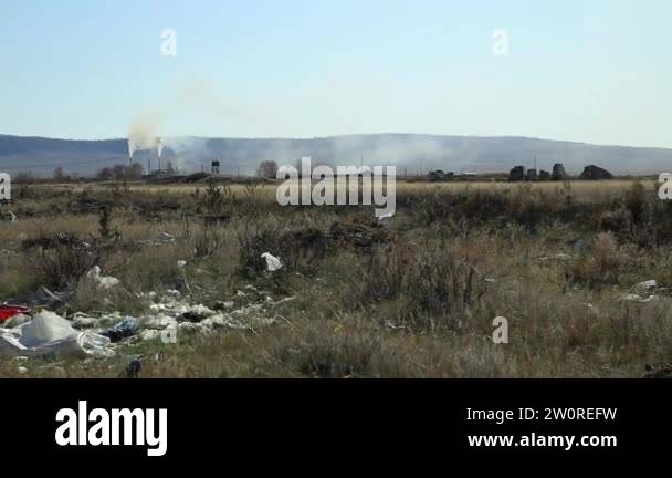 Garbage dump, waste dump in the field against the background of Smoking ...