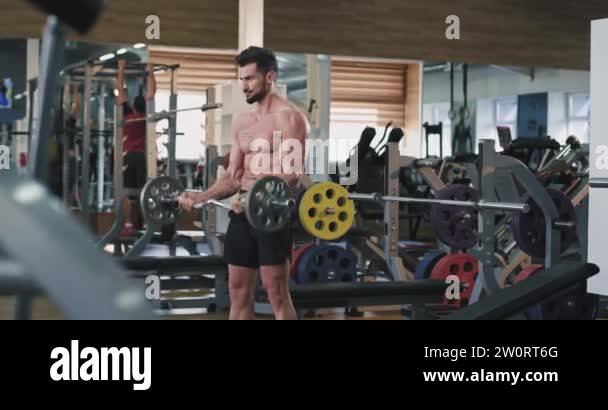 Handsome bodybuilding man working hard at gym class exercises hard to ...