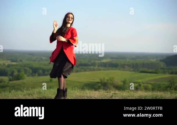 Georgian woman dances national dance in red national dress on the green ...