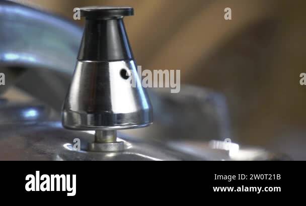 Pressure cooker valve relieves pressure and rotates. Close-up of a ...
