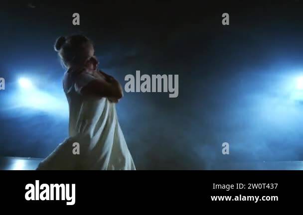 A woman in a white dress is dancing on the stage the dramatic dances of ...