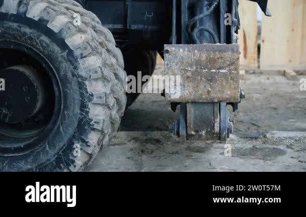 Close-up heavy industrial wheeled excavator extracting outrigger ...