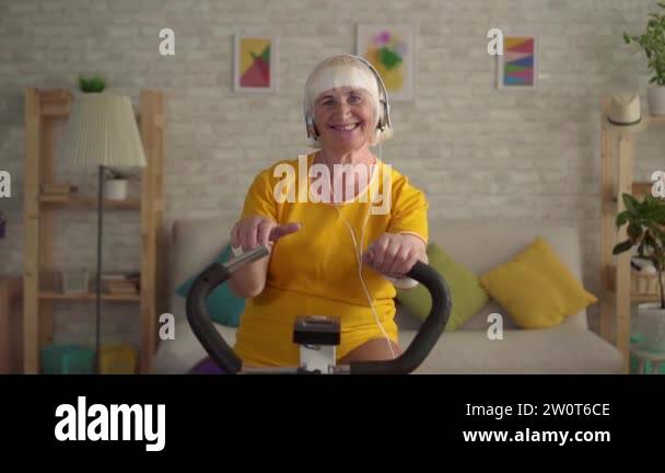 positive fitness senior woman shows thumb up and smiles while doing ...