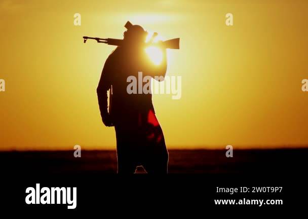 Islamic warrior with Kalashnikov at sunset day. Muslim fighter is ...