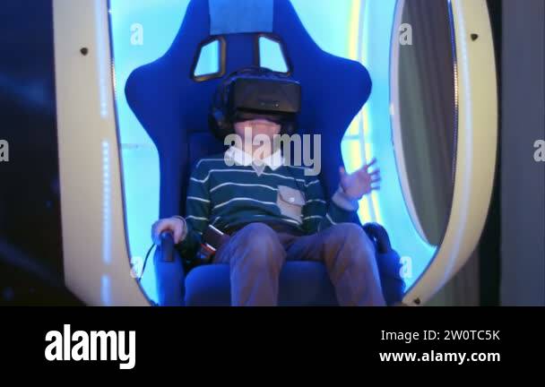 Surprised little boy experiencing virtual reality in a moving ...