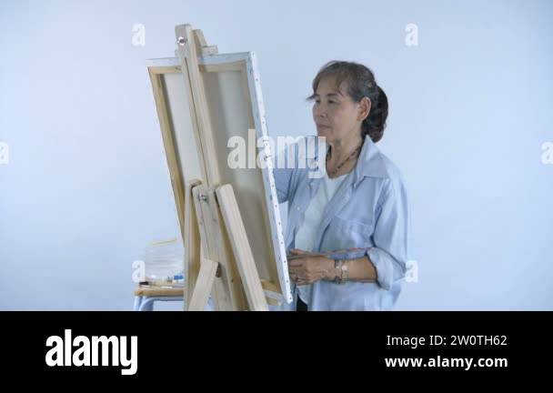 Artist Concept. A middle aged woman drawing in a studio room. 4k ...