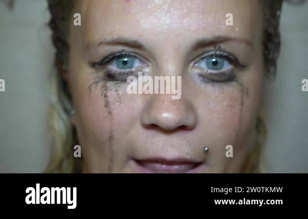 Smeared mascara on female eyes. A wet girl is looking into the frame ...