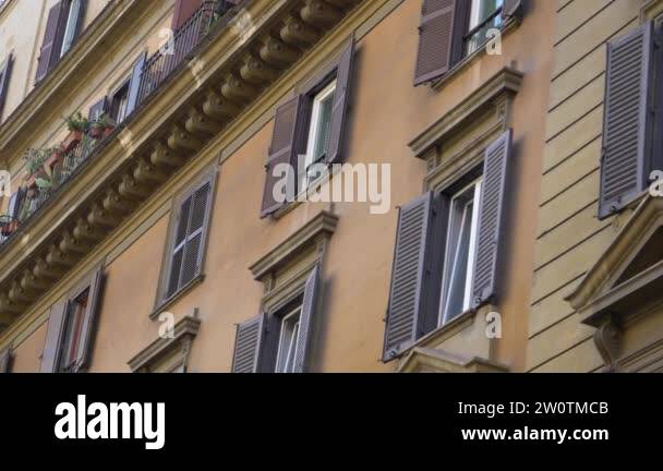 CLOSE UP: Windows of old residential building in Rome look down on ...
