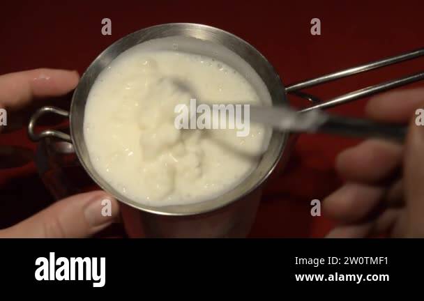 Pouring of Kefir. The mixture of fermented milk and granules is ...