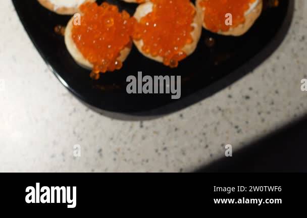 Red caviar is put with a spoon on tartlets with cottage cheese ...