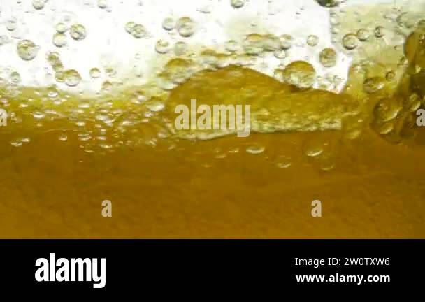 Bubbles of golden fluid. The olive oil is stirred in a circle in a bowl ...