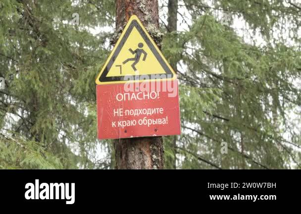 Danger sign of man falling from cliff. Stock footage. Sign hanging from ...