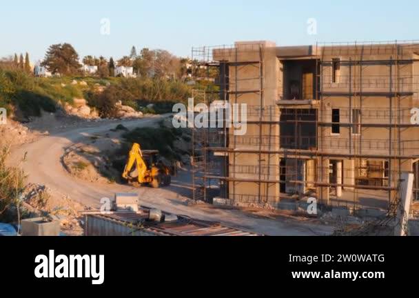 Construction of villas on seashore. Building of house on beach. Tractor ...
