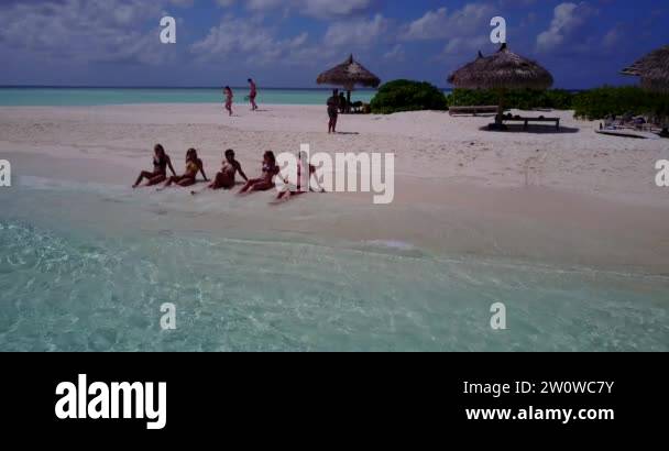 video the tan girls in bikini lying in a row on the white sandy beach ...