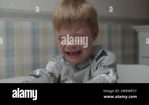 Upset blonde boy crying with emotions on his face in slow motion ...