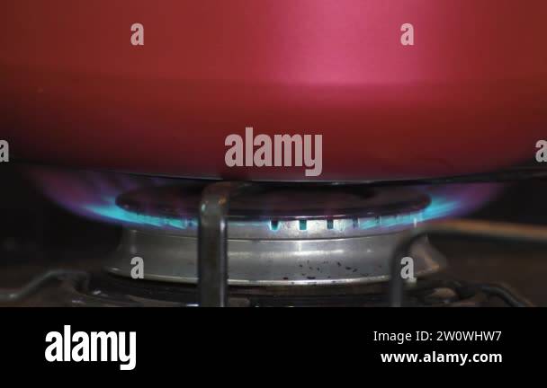 Heating a pan on the burner of a gas range. Close-up on the fire ...