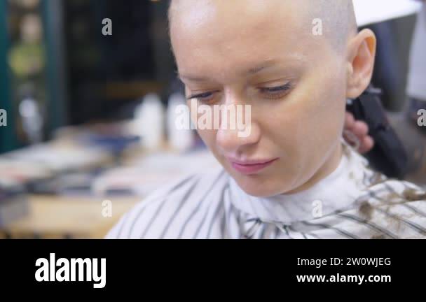 concept of hair loss after chemotherapy. the hairdresser shaves the rest of the hair on the head ...