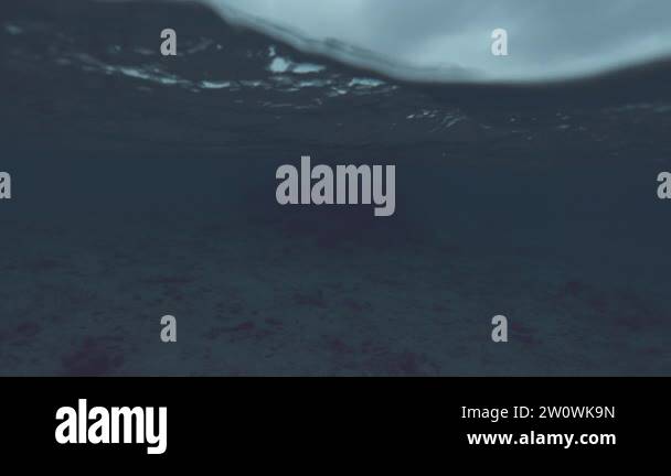 SLOW MOTION, UNDERWATER, DOF: Gentle little wave rolls over the submerged camera in the dark sea ...