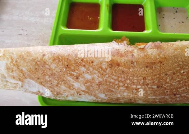 POV of a man eating thosai. A dosa (thosai, tosai) is a type of pancake ...