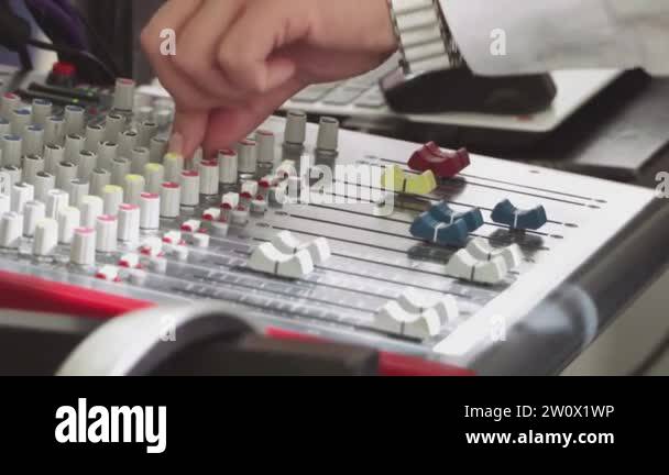 The DJ s hands touch the buttons and sliders that play electronic music ...