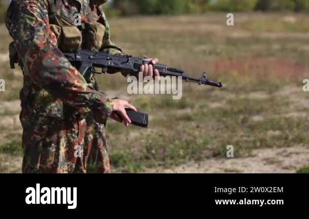 A man in camouflage charges a magazine with bullets into a black ...