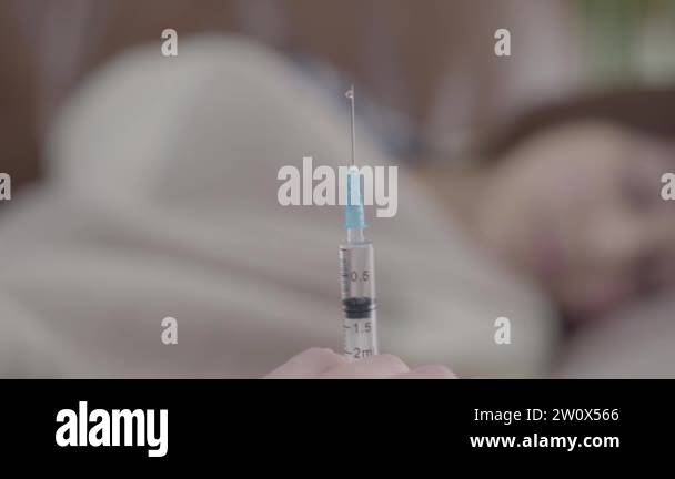 The nurse sprays drug from a syringe preparing for making injection in ...