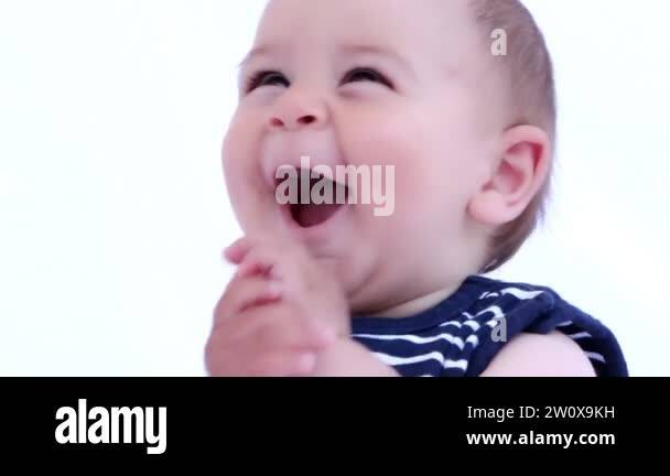 Happy baby boy is laughing and clapping with hands on a white ...