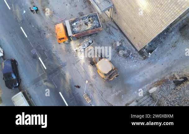 Bulldozer loader uploading waste and debris into dump truck at ...