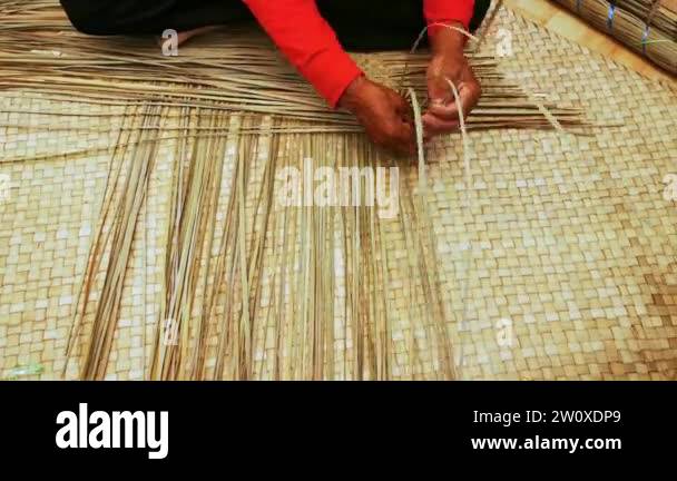 Close up shot of an expert old female hands weaving mat in Terengganu ...